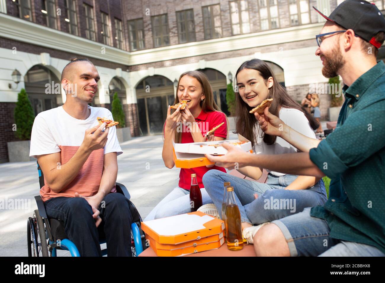 Together. Group of friends taking a stroll on city's street in summer ...