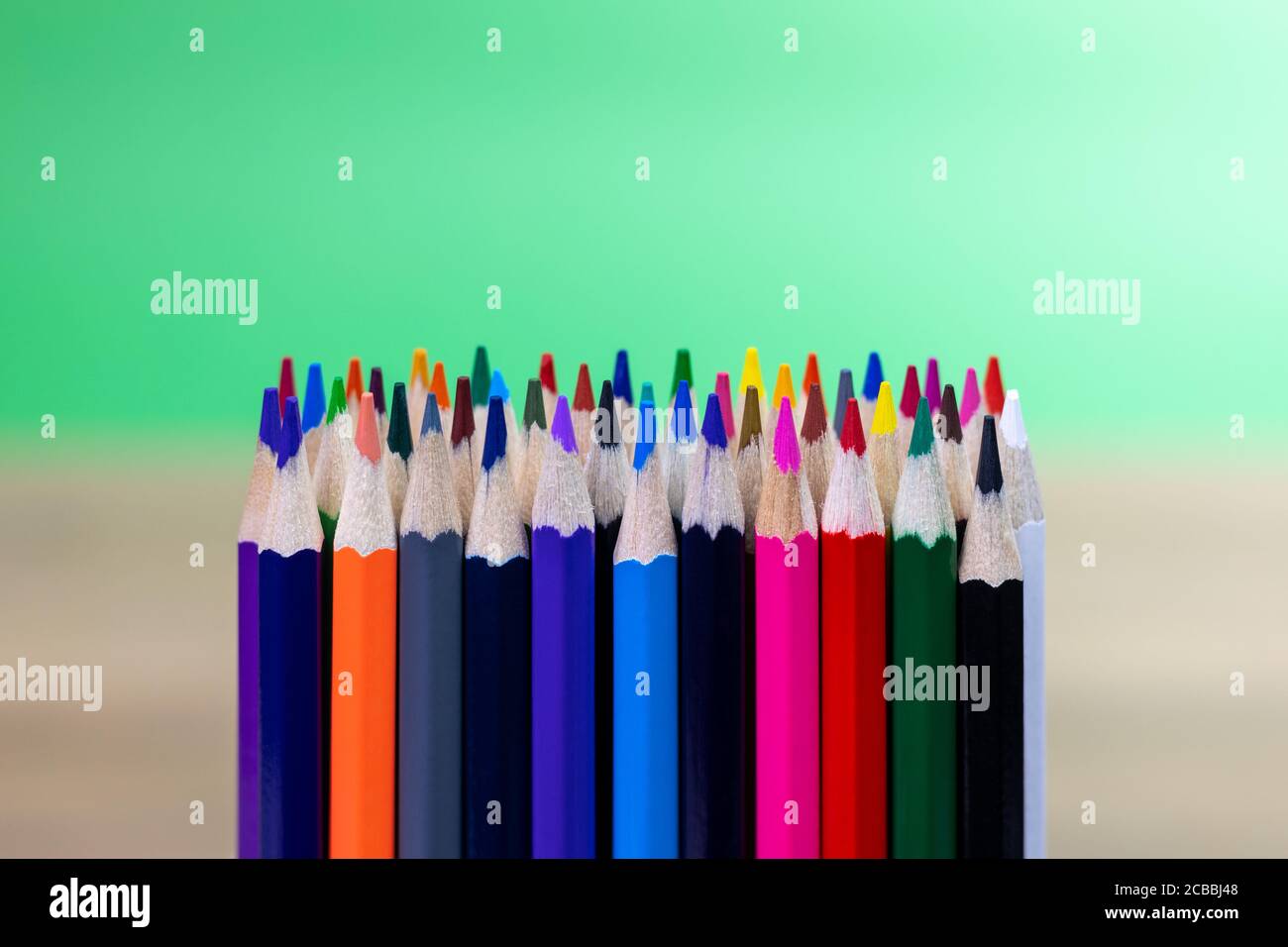 close up view of colored pencils aligned vertically with green and ...