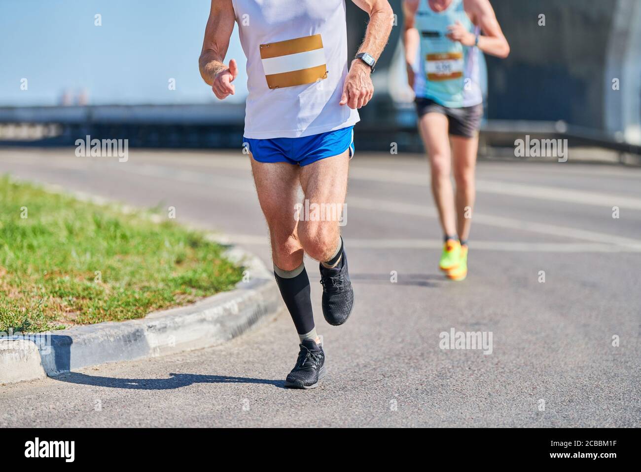 Running man. Athletic man jogging in sportswear on city road. Street marathon race, sprinting ...