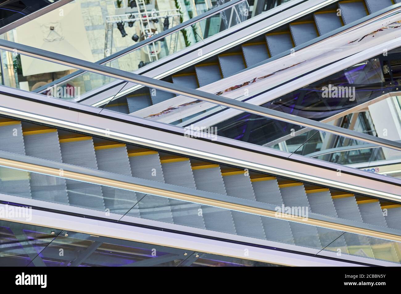 Crisscross escalators in shopping center. Empty escalators stairs up and down in office building ...