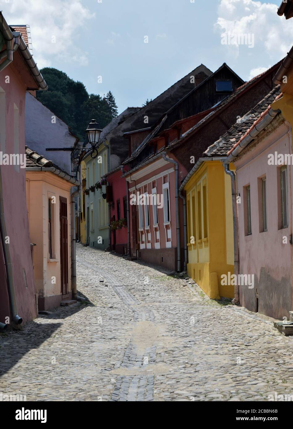 Stone paved old streets with colorful houses in Sighisoara fortress ...