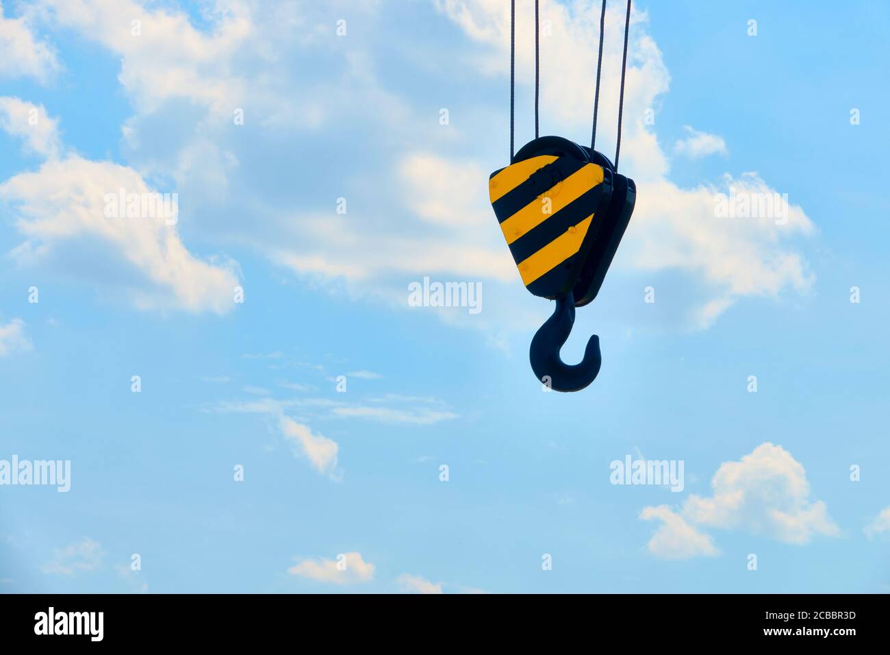 Heavy duty hooks on ropes with yellow-black guides in front of a white ...