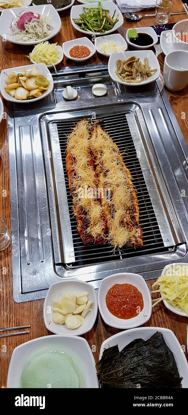 Vertical high angle shot of Korean barbecue with sides and sauces at a ...