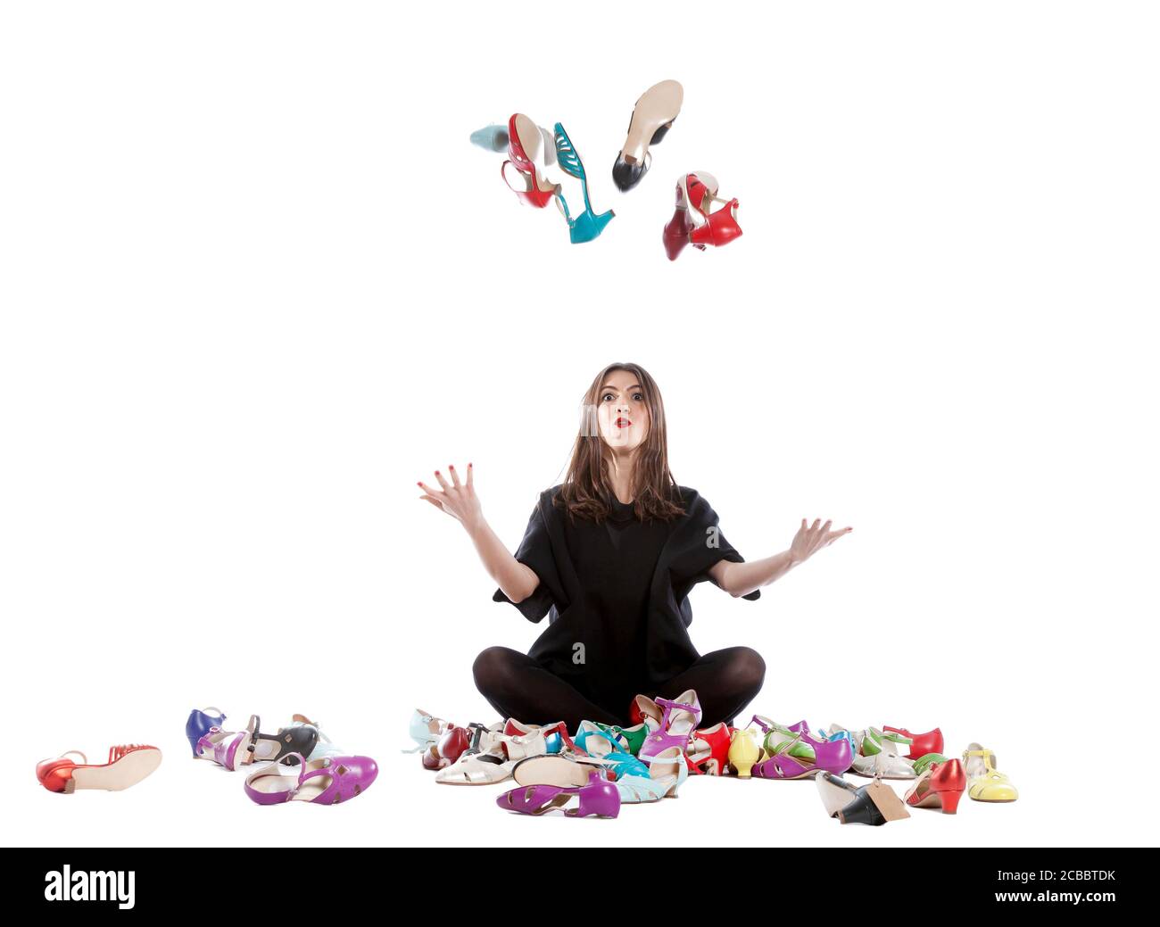 Young woman isolated on white background having a lot of shoes with ...