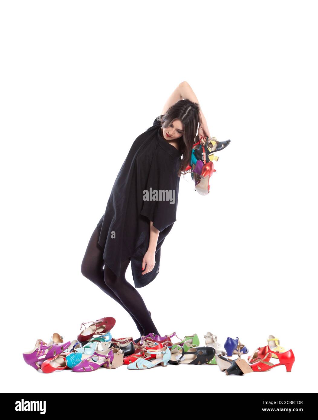 Young woman isolated on white background having a lot of shoes with ...