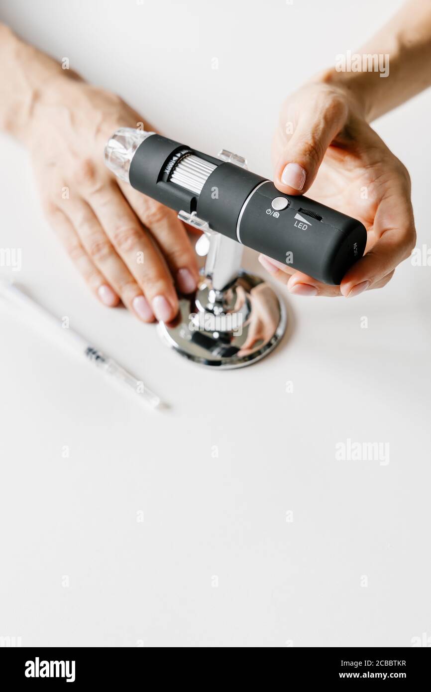 Skin microscope in hands Stock Photo - Alamy