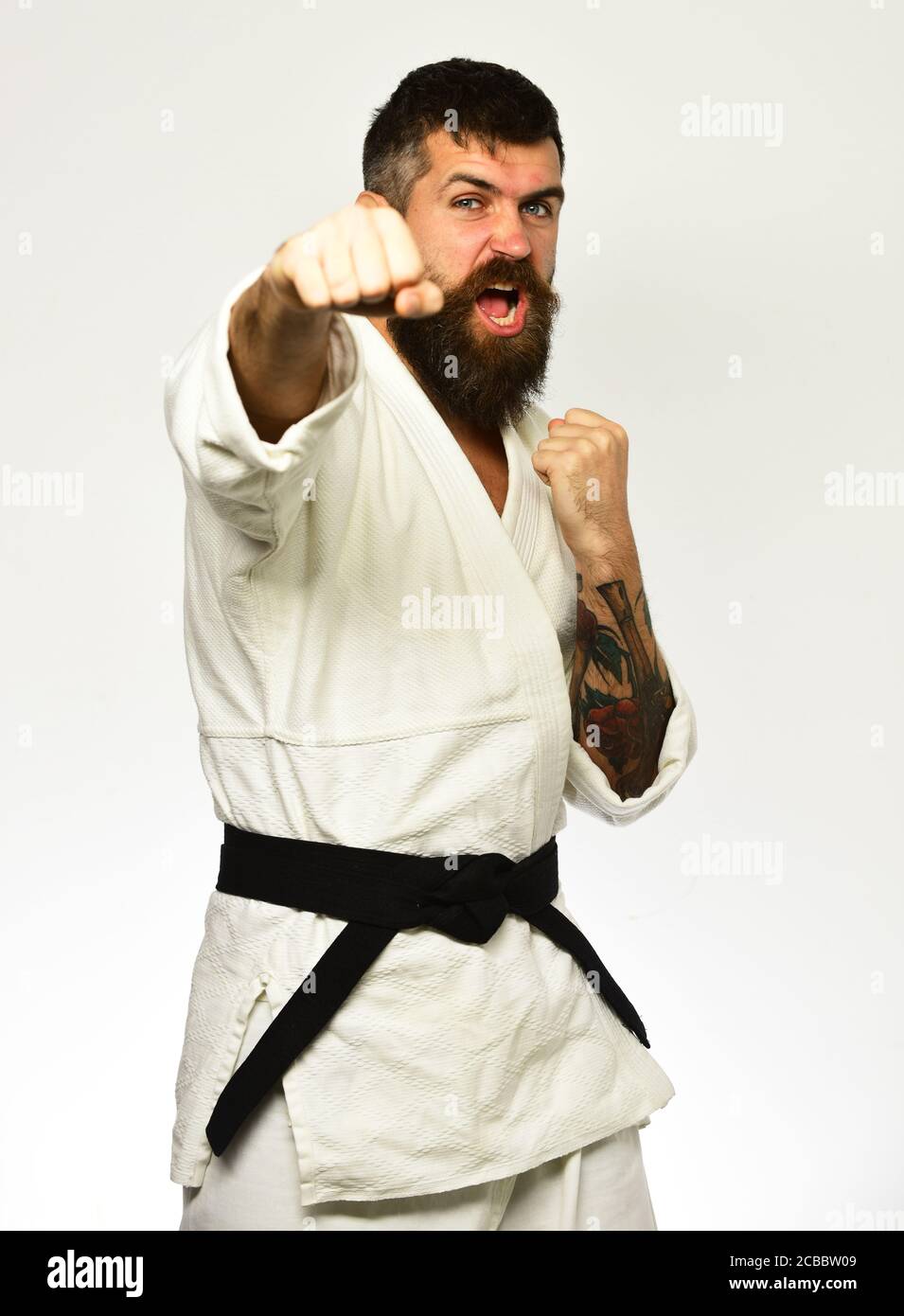 Karate man with angry face in uniform. Man with beard in white kimono ...
