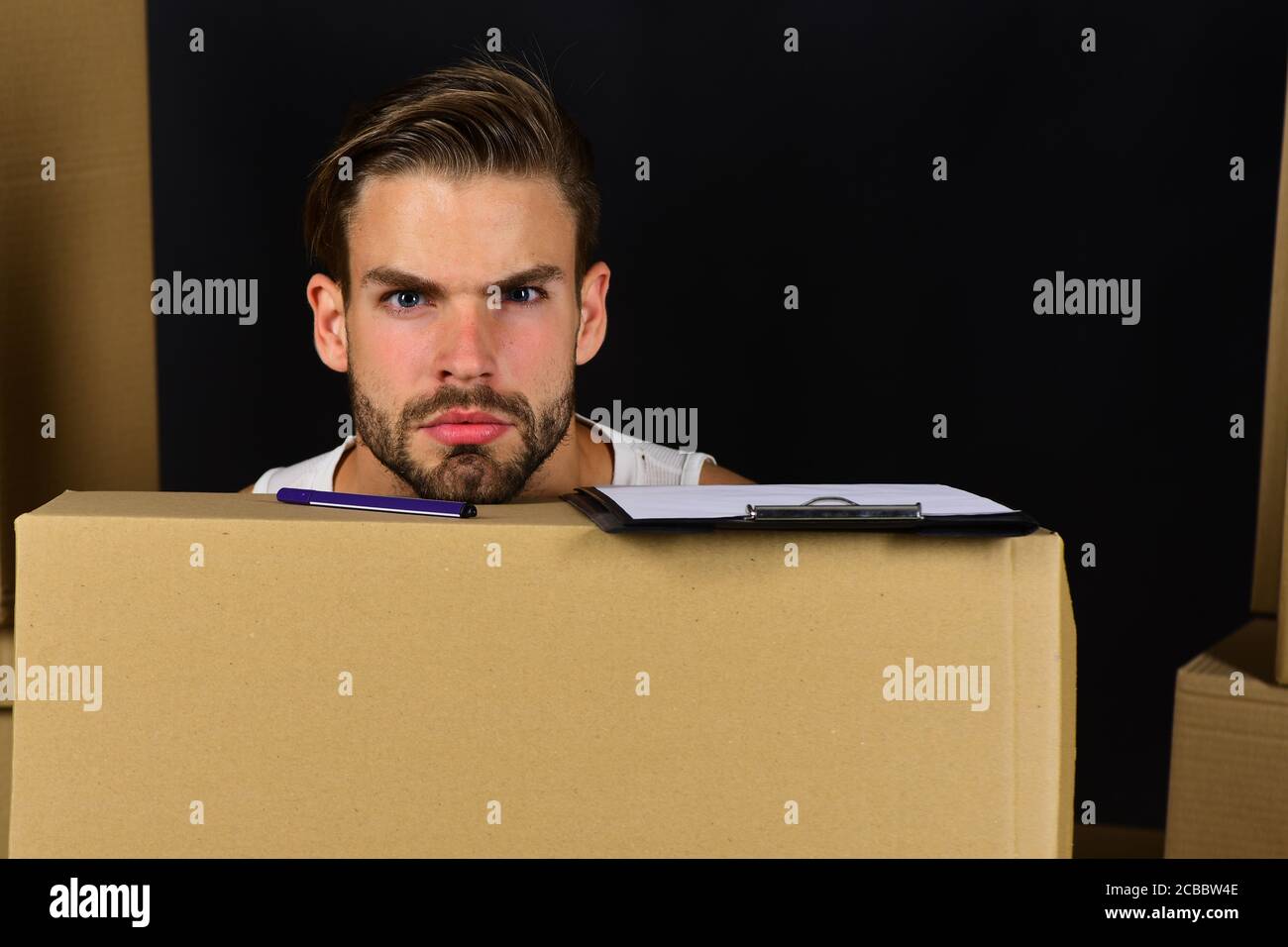 Delivery and moving in concept. Macho with beard and suspicious face ...