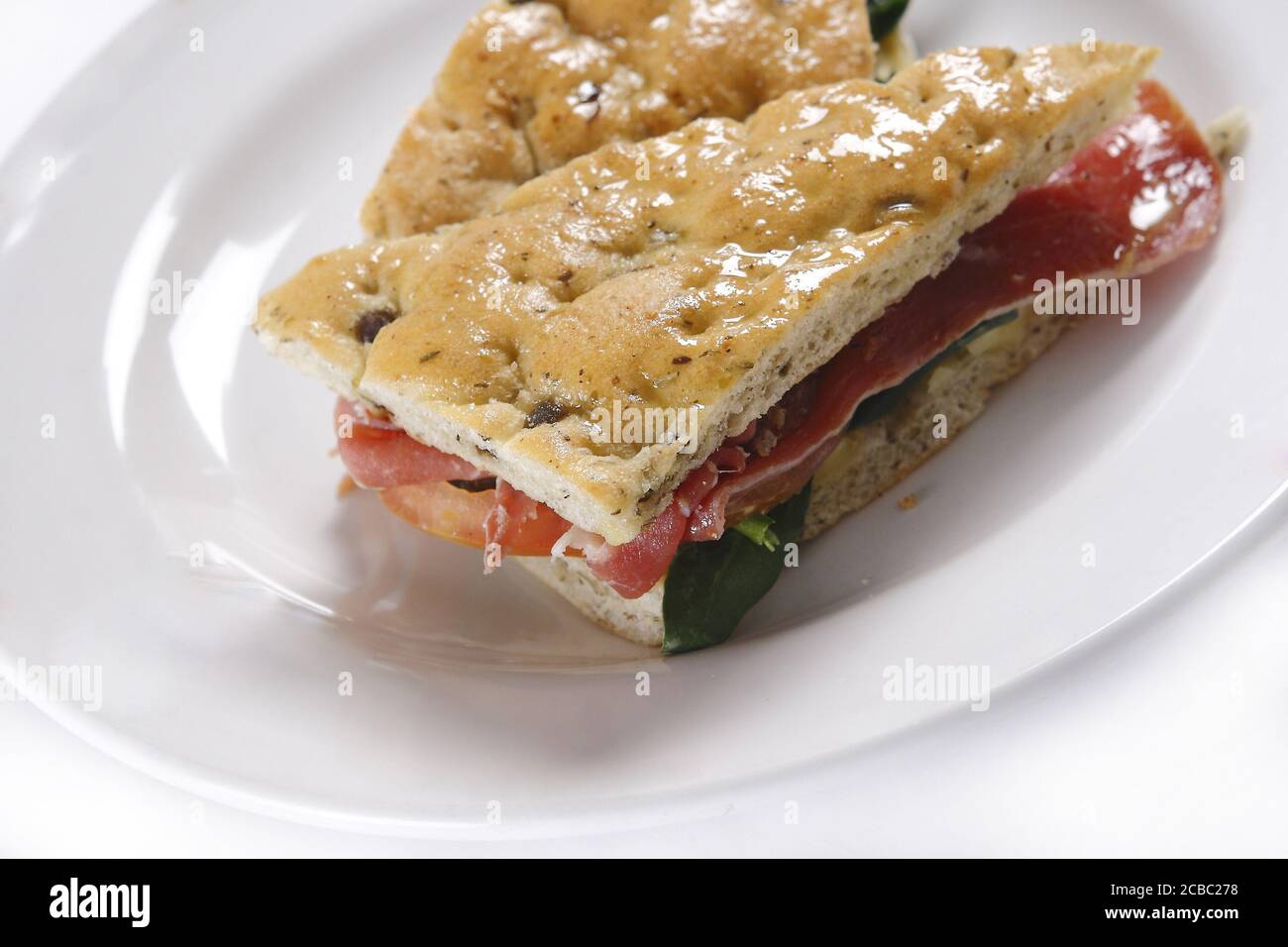 Closeup shot of triangle bread sandwich with serrano ham, spinach, and ...