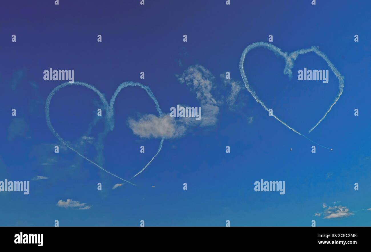 Inversion trail of the plane. A small plane makes a heart figure Stock ...