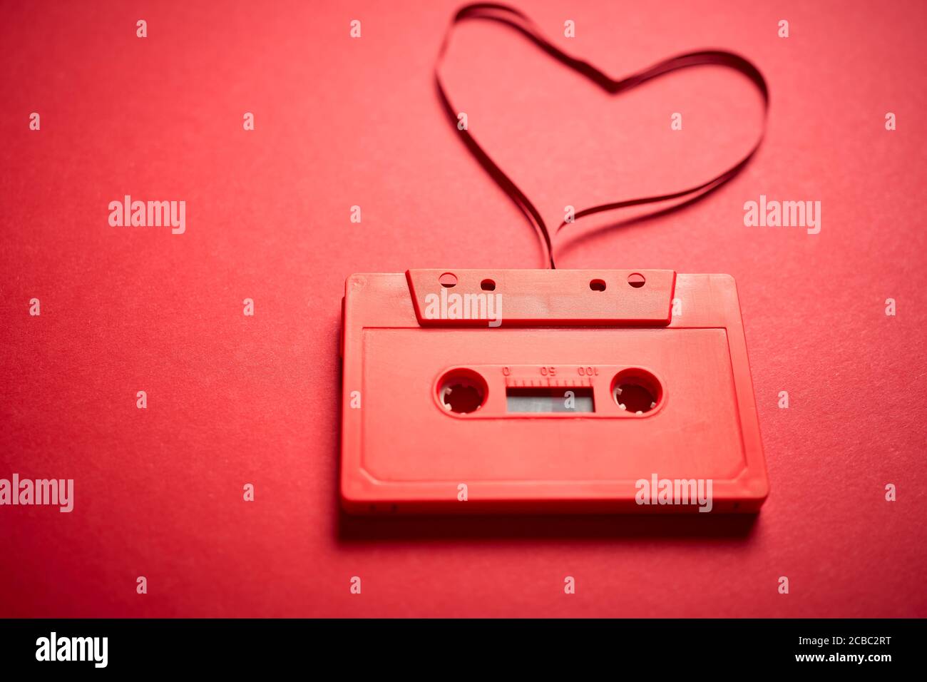 old red cassette tape on a minimalist background Stock Photo - Alamy