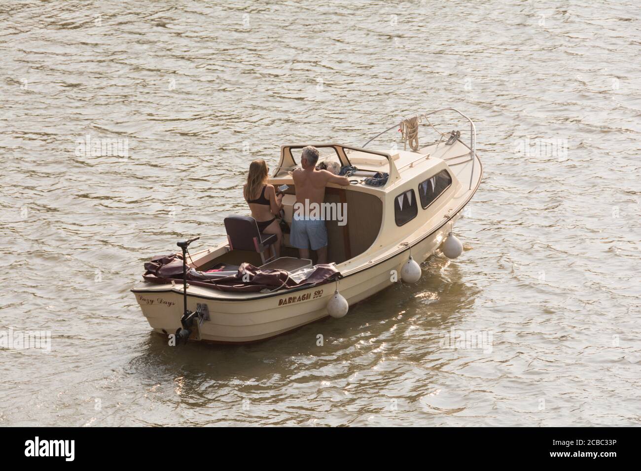 A man and a woman on a small motor launch on the River Thames, London ...