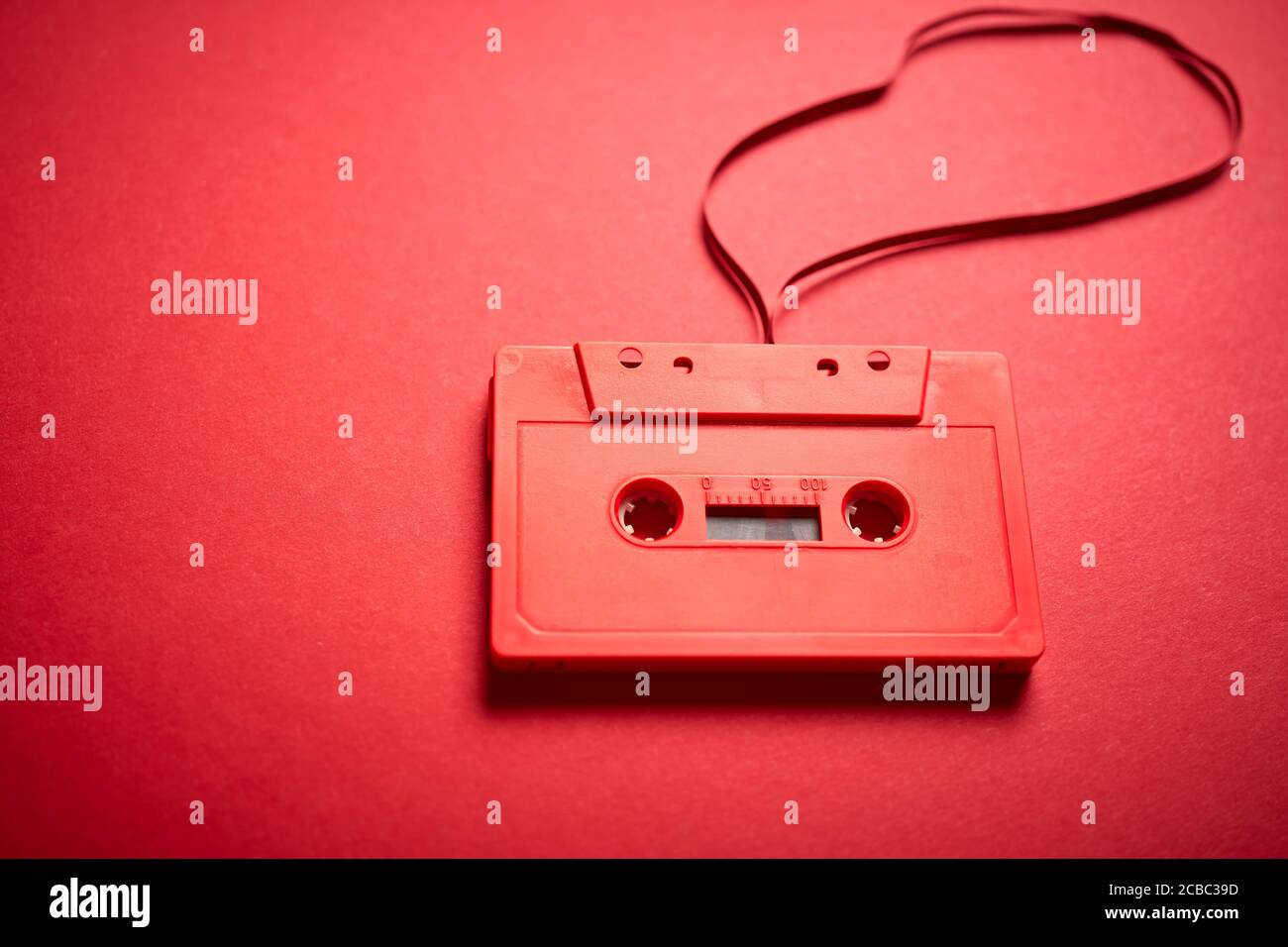 old red cassette tape on a minimalist background Stock Photo - Alamy