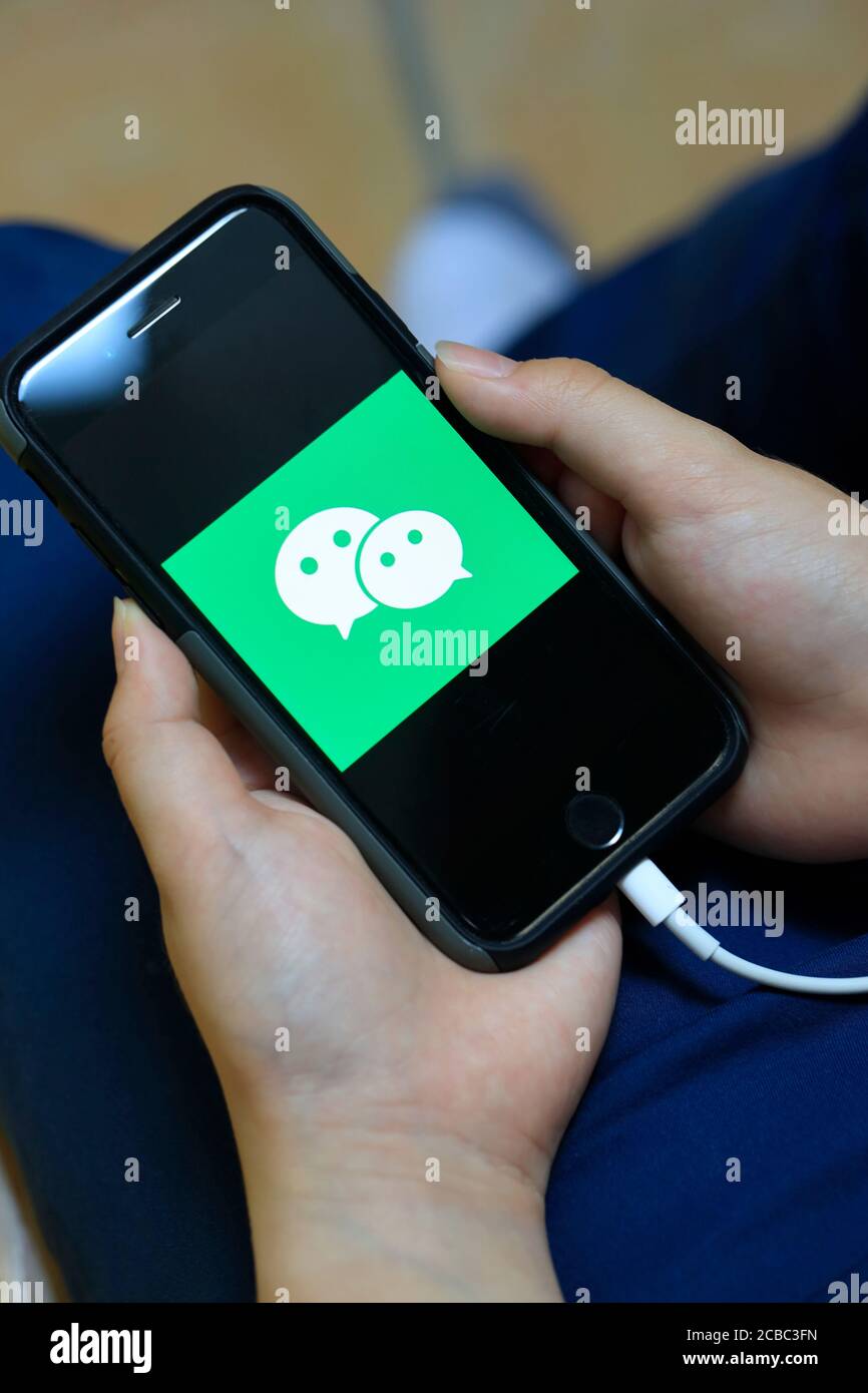 Hands holding an iPhone with logo of WeChat on it's screen Stock Photo ...