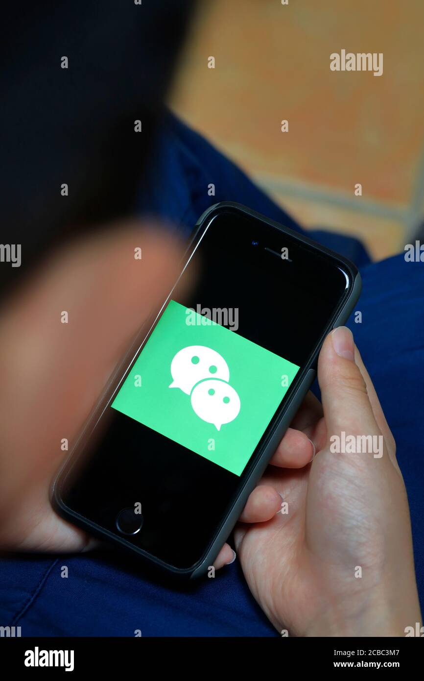 Hands holding an iPhone with logo of WeChat on it's screen Stock Photo ...