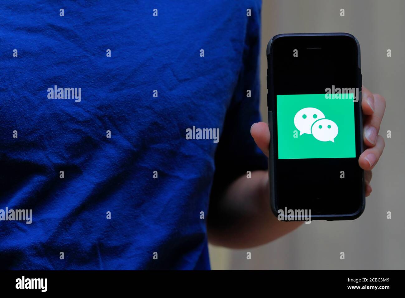 A hand hold an iPhone with the logo of WeChat on it's screen Stock ...