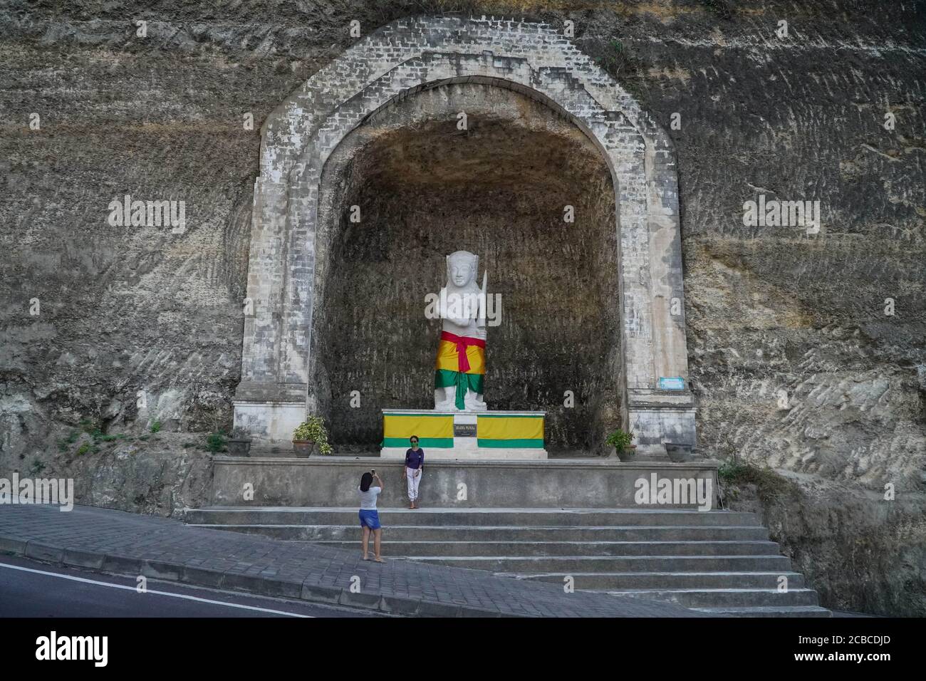 Tourists taking photograph next to a giant statue in Pandawa Beach ...