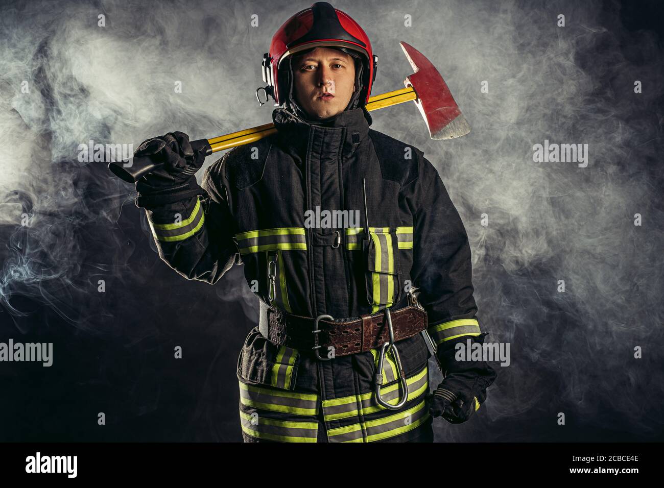 young caucasian handsome and strong fireman in uniform wearing helmet ...