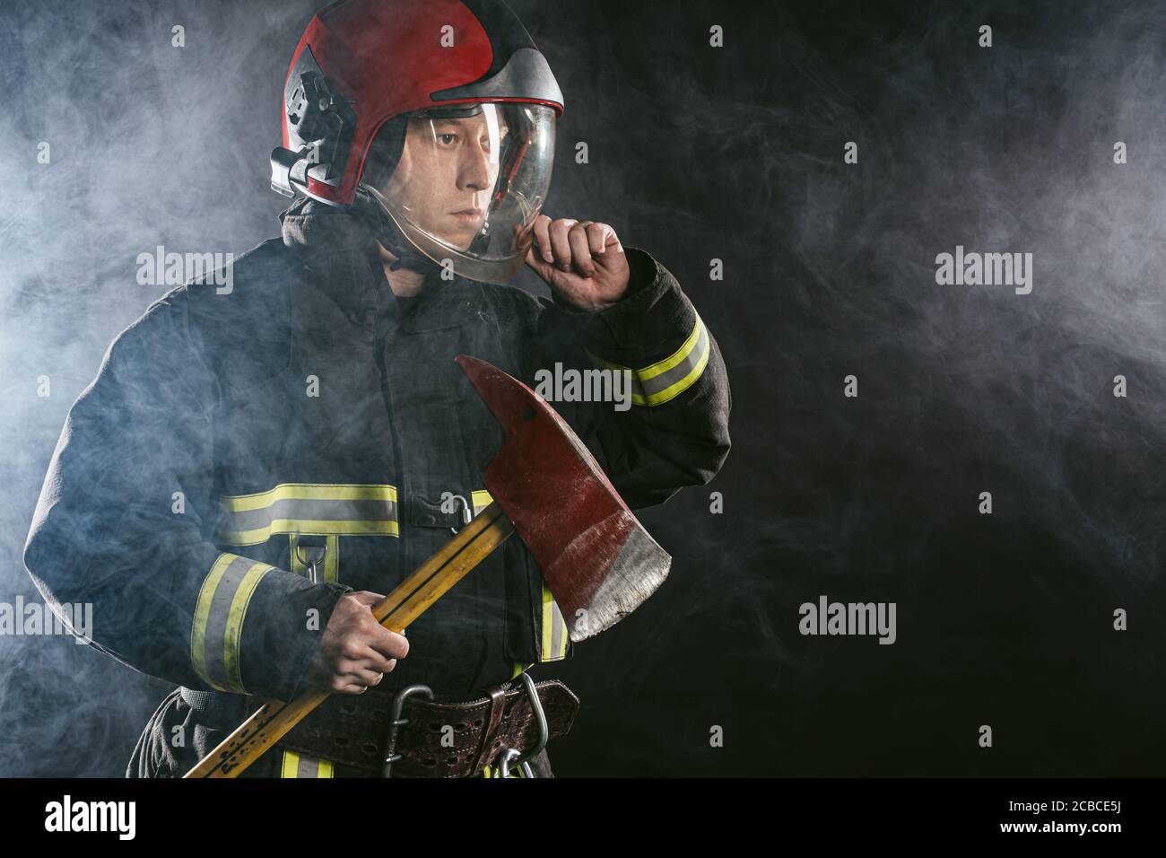 young caucasian handsome and strong fireman in uniform wearing helmet ...