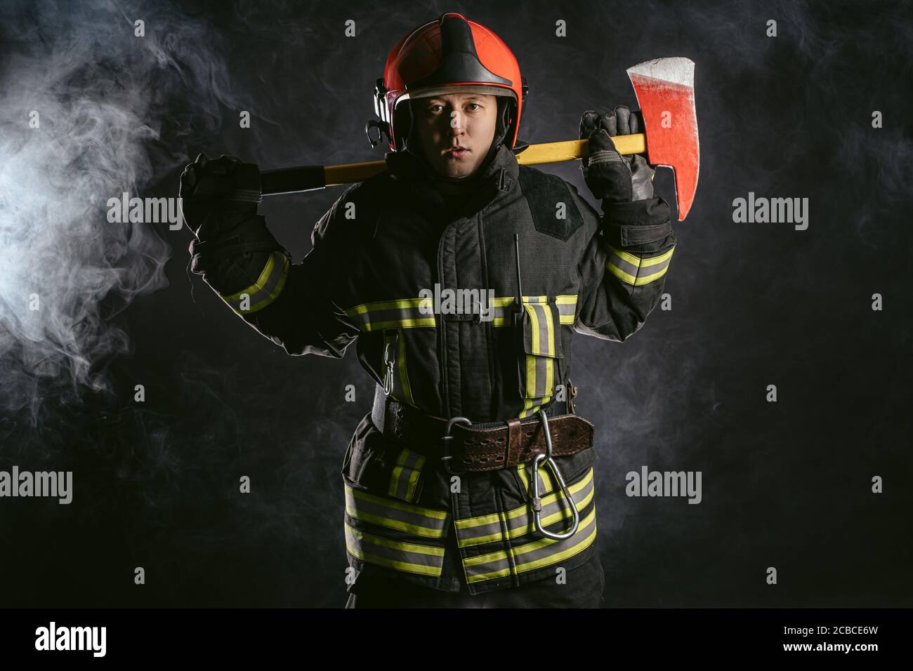 young adult firefighter saving people from fire wearing uniform and ...