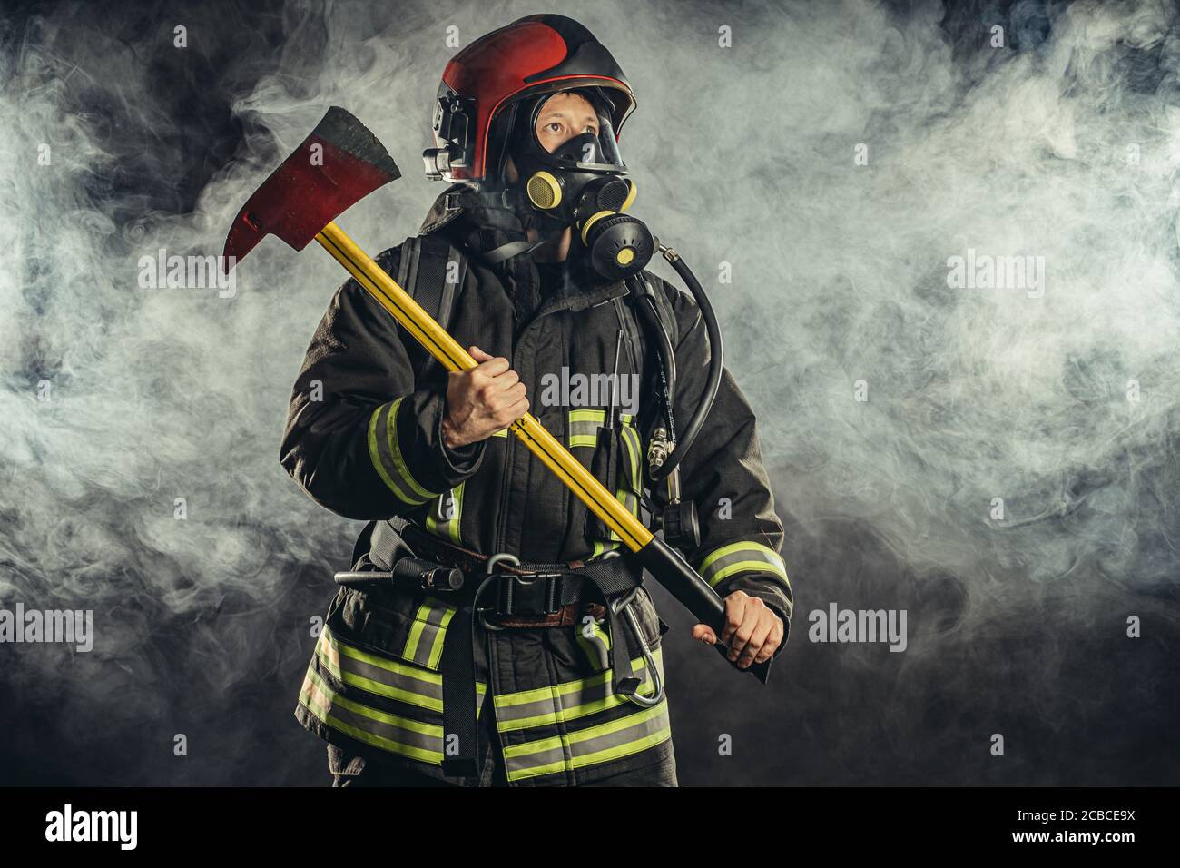 portrait of serious and confident caucasian fireman stand holding ...