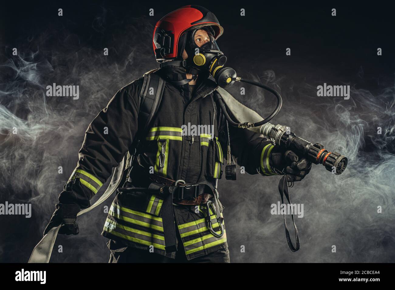 brave firefighter extinguishing fire in smoke, using special equipment ...