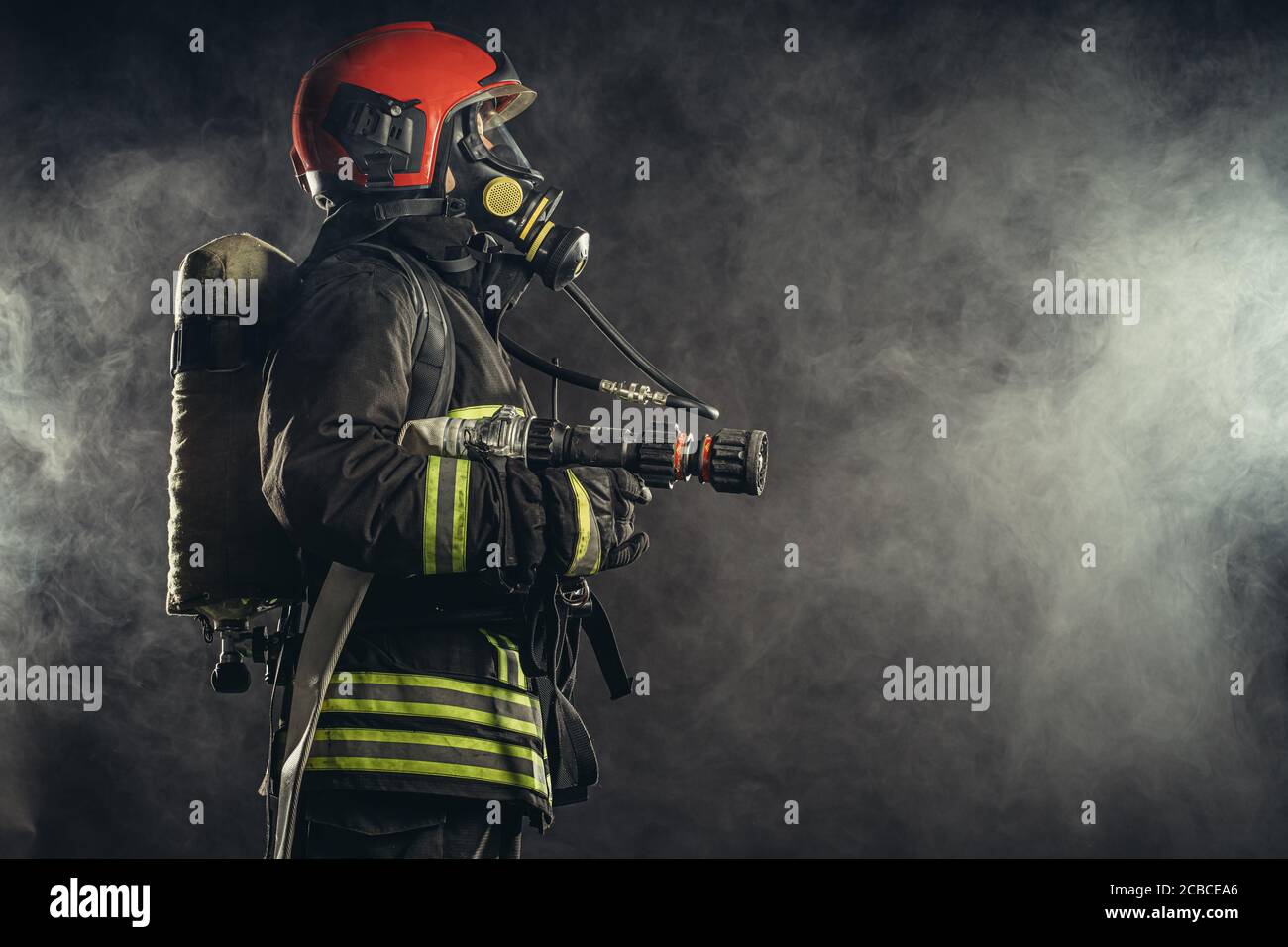 young firefighter in uniform stand in smoky background wearing uniform ...