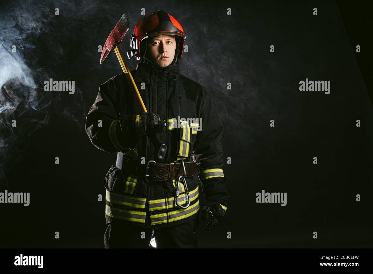 portrait of serious and confident caucasian fireman stand holding ...