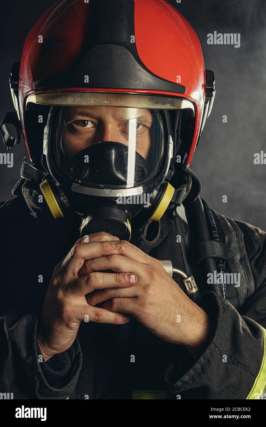 portrait of confident handsome fireman in helmet and uniform, serious ...