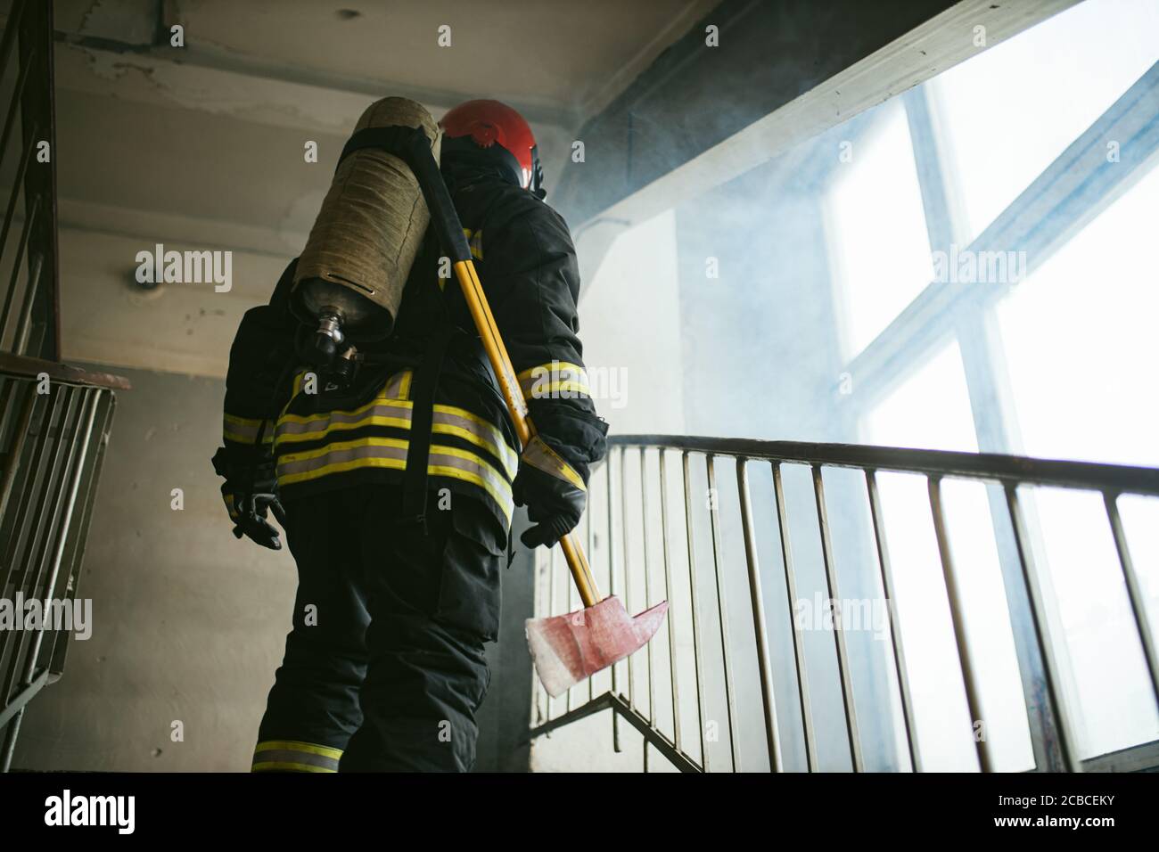 strong middle-aged fireman going to save and protect people from fire ...