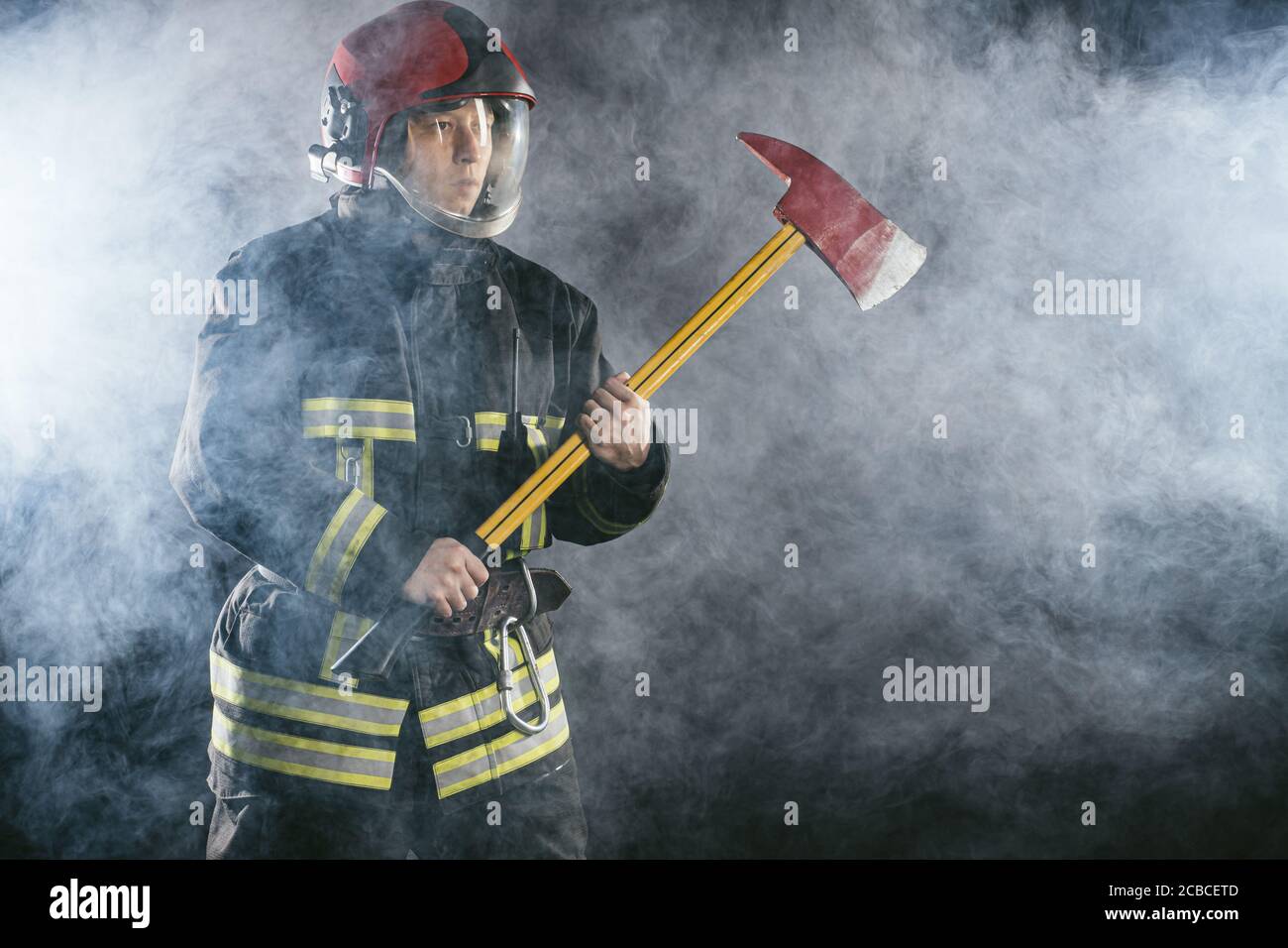 young adult firefighter saving people from fire wearing uniform and ...