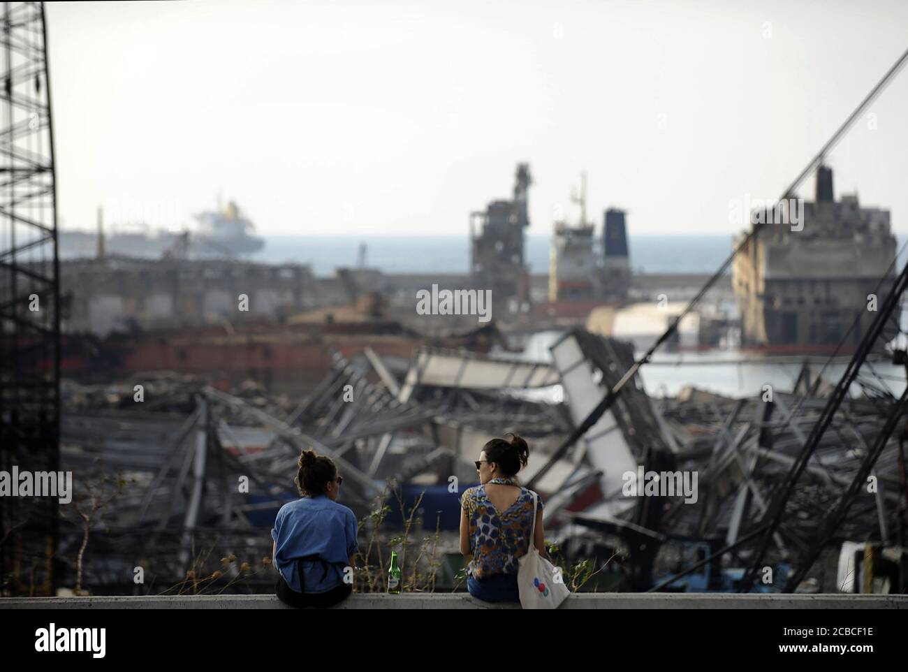 Beirut, Lebanon. 12th Aug, 2020. Two women overlook the damaged port ...