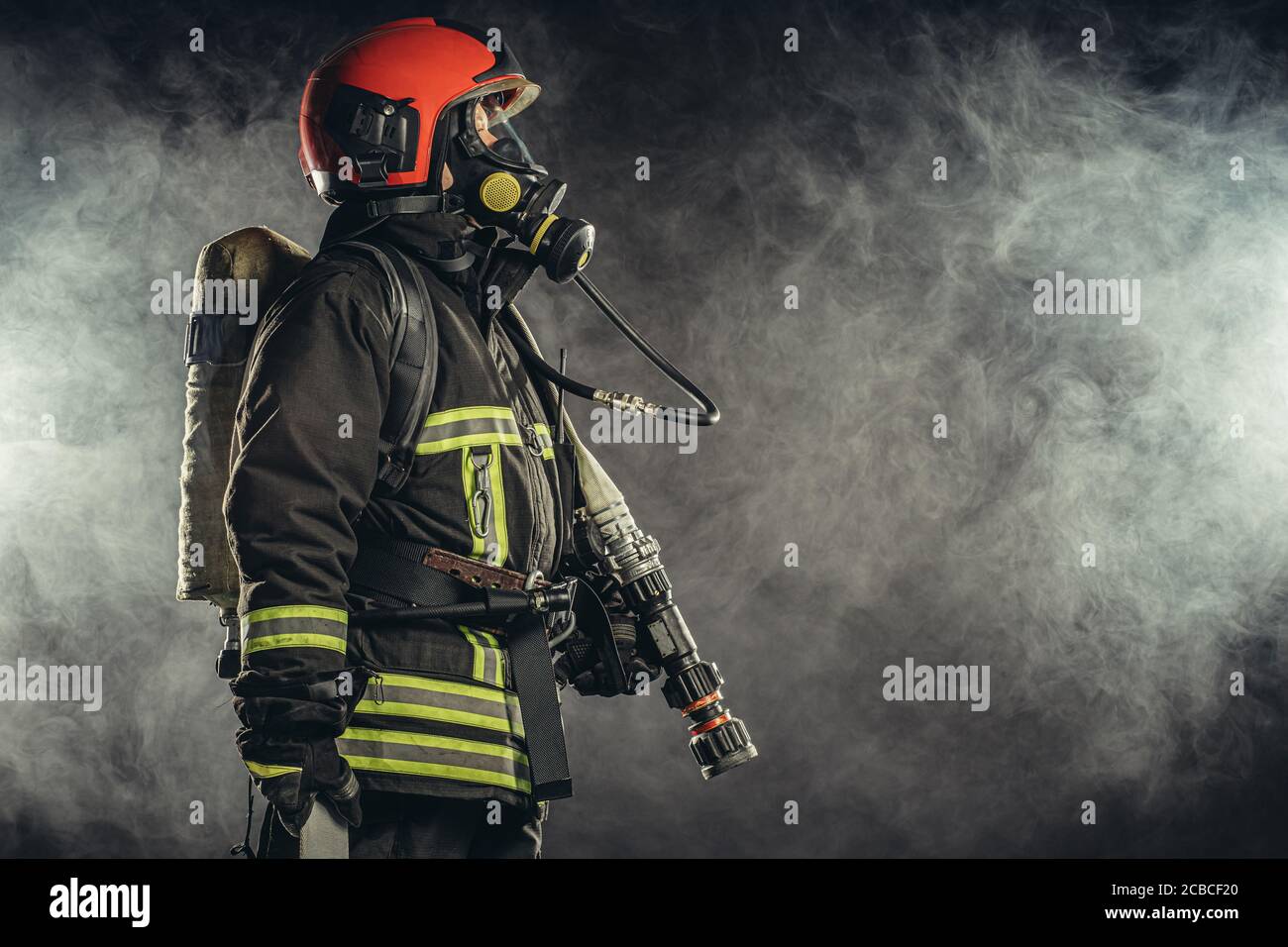 strong firefighter in protective suit and helmet use special equipment ...