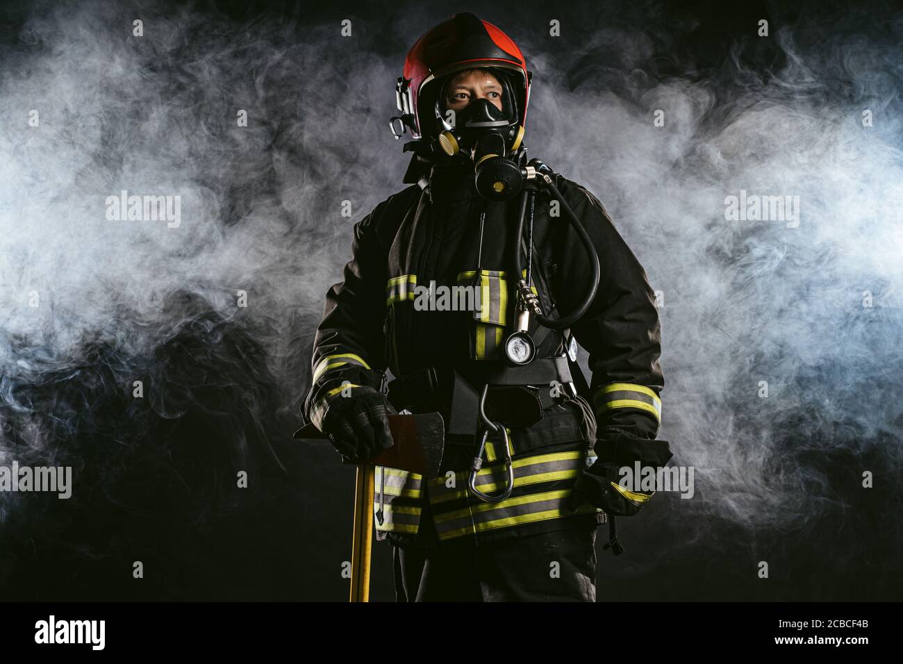 Male firefighter extinguishing fire in hi-res stock photography and ...