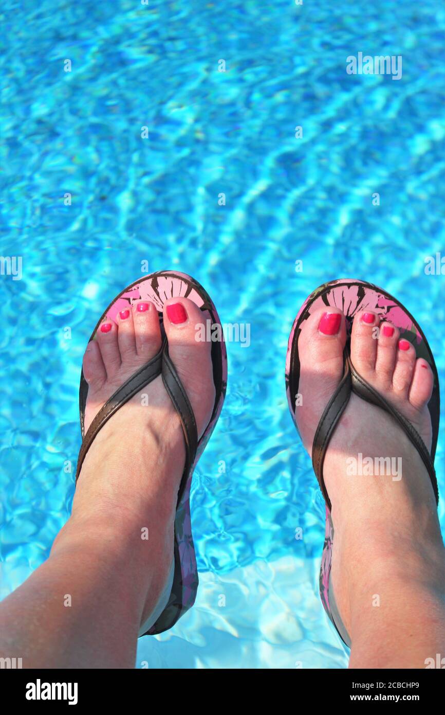 Female feet in a pool with a flip flops on Stock Photo - Alamy