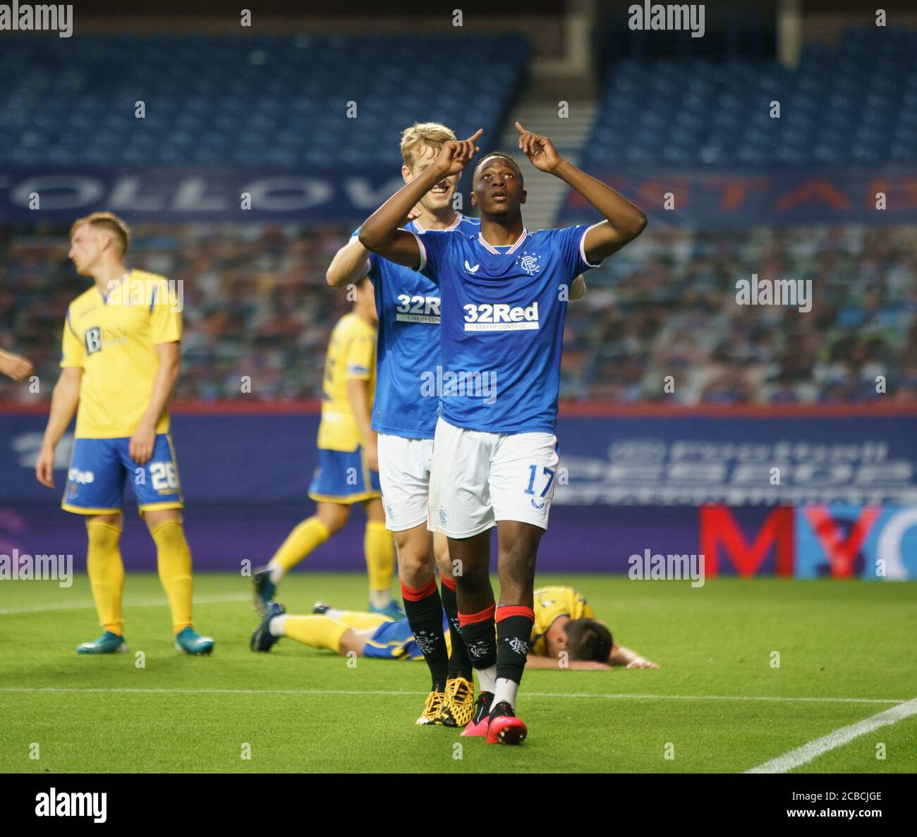 Joe Aribo of Rangers celebrates, chased by team mate Filip Helander ...