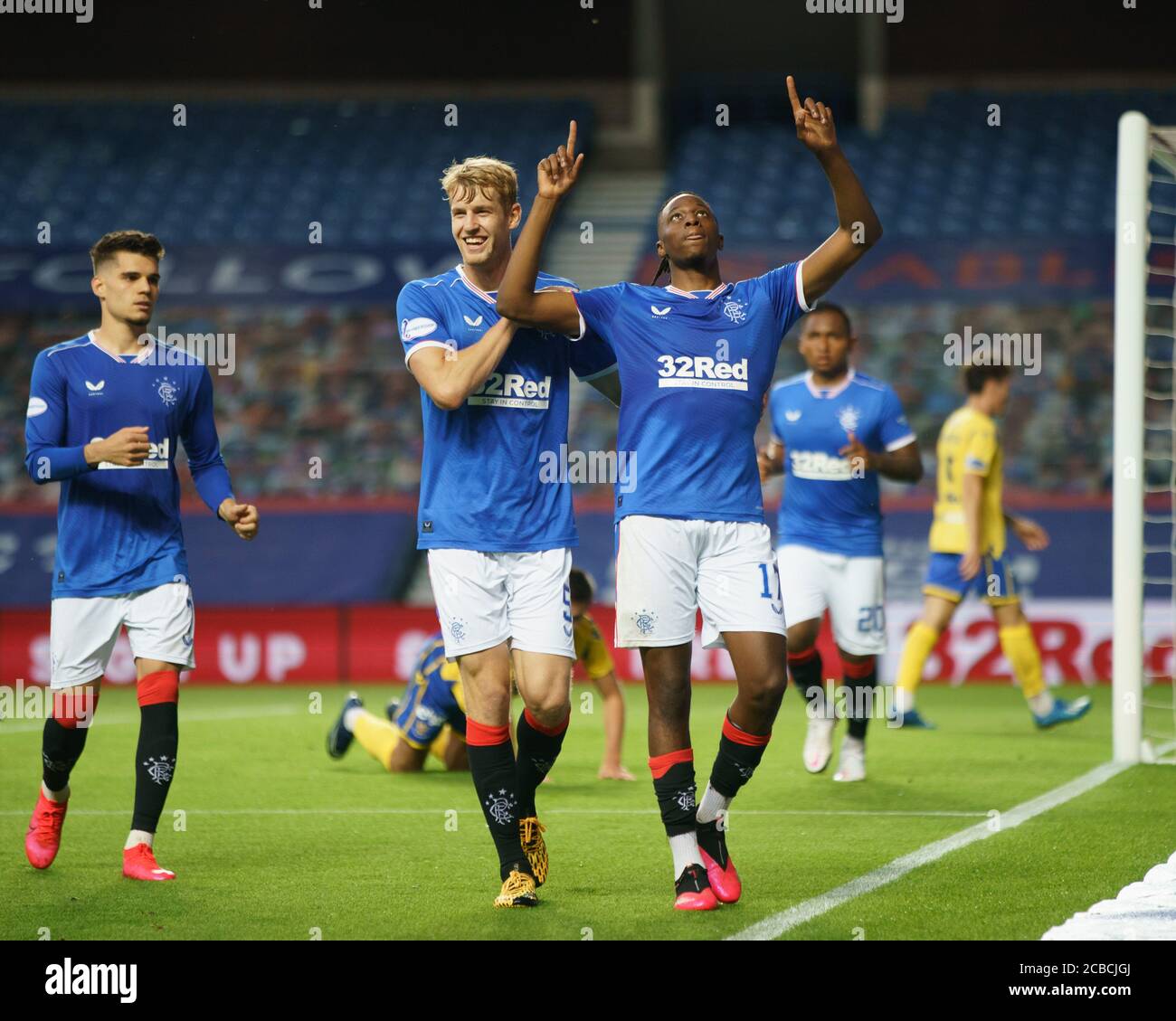 Joe Aribo of Rangers celebrates, chased by team mate Filip Helander ...