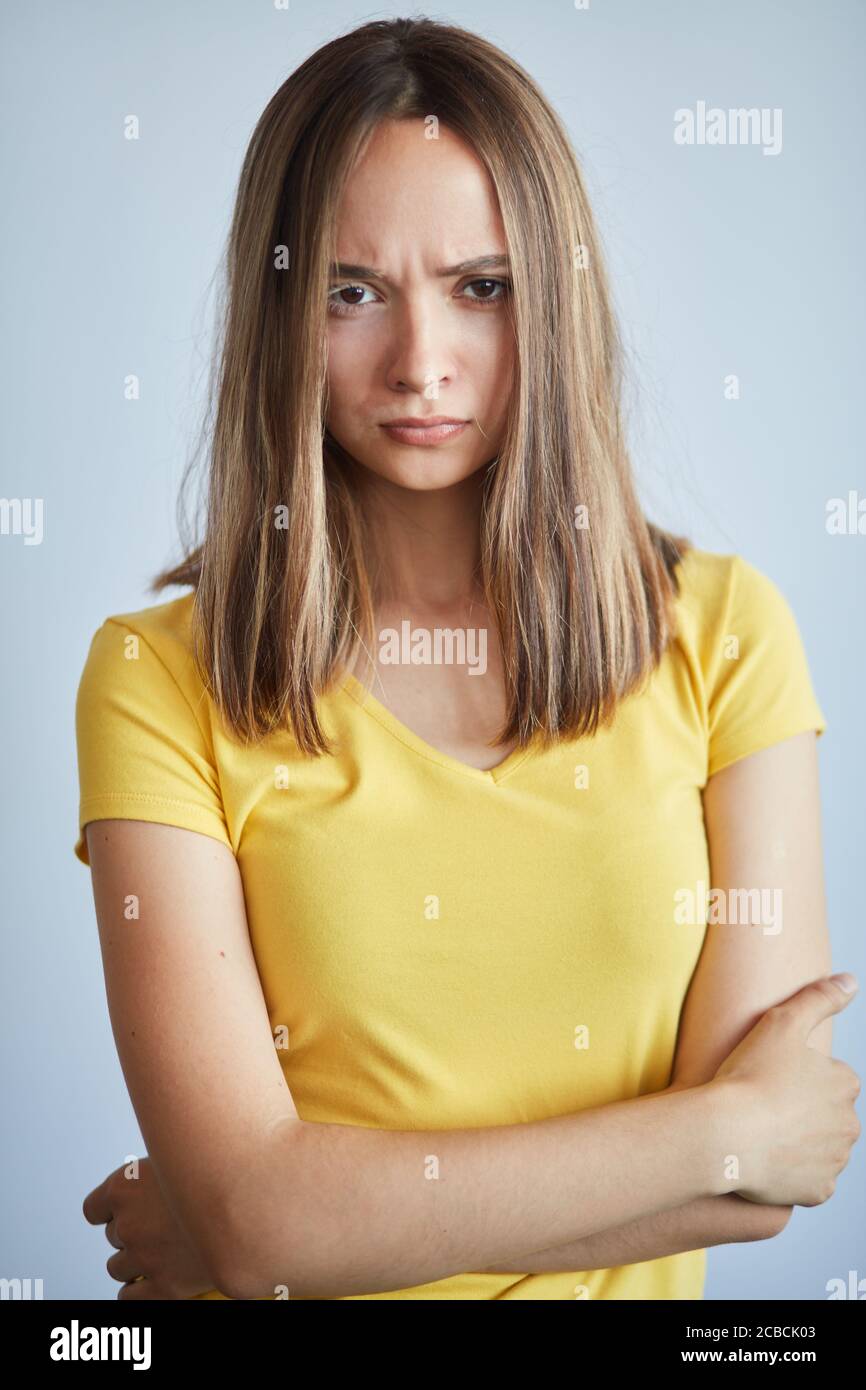 guilty emtional depressed girl with crossed arms , and frowned eyebrows ...