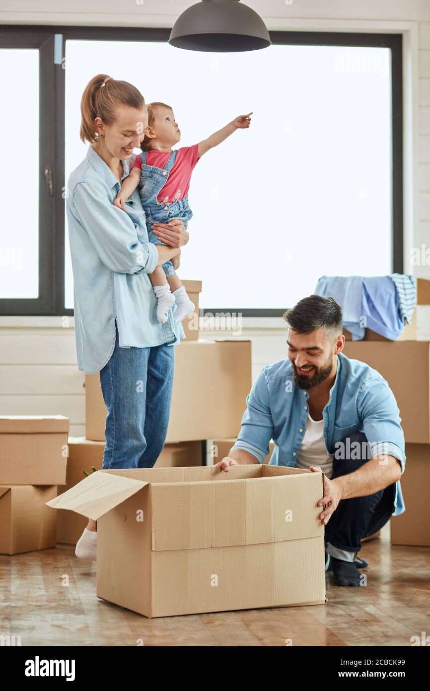 Father sit look into box and smile. Mom keep in hands child. In ...