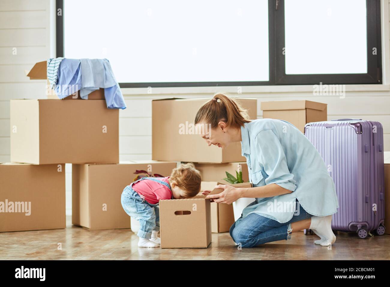 In center photo little child looks in box. Mother blonde woman wear ...