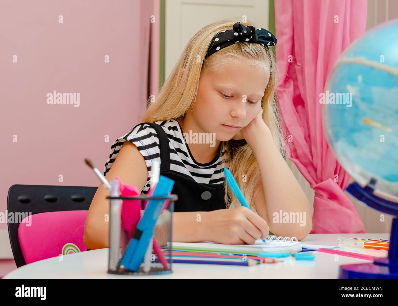 Blonde girl doing her homework. Boring education concept Stock Photo ...