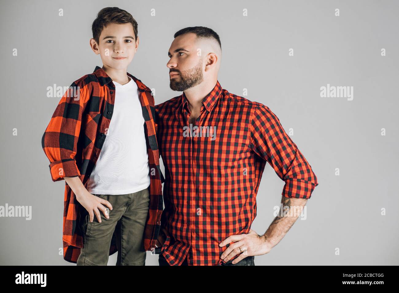 serious handsome father looking at his child isolated on the grey ...