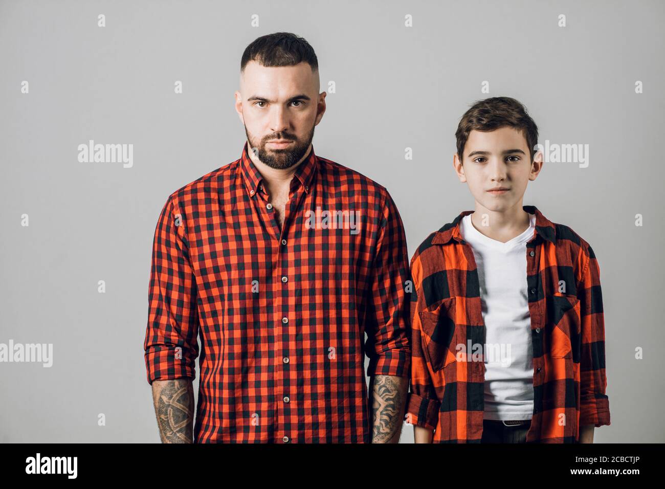 serious two brothers in shirts posing to the camera. close up photo ...