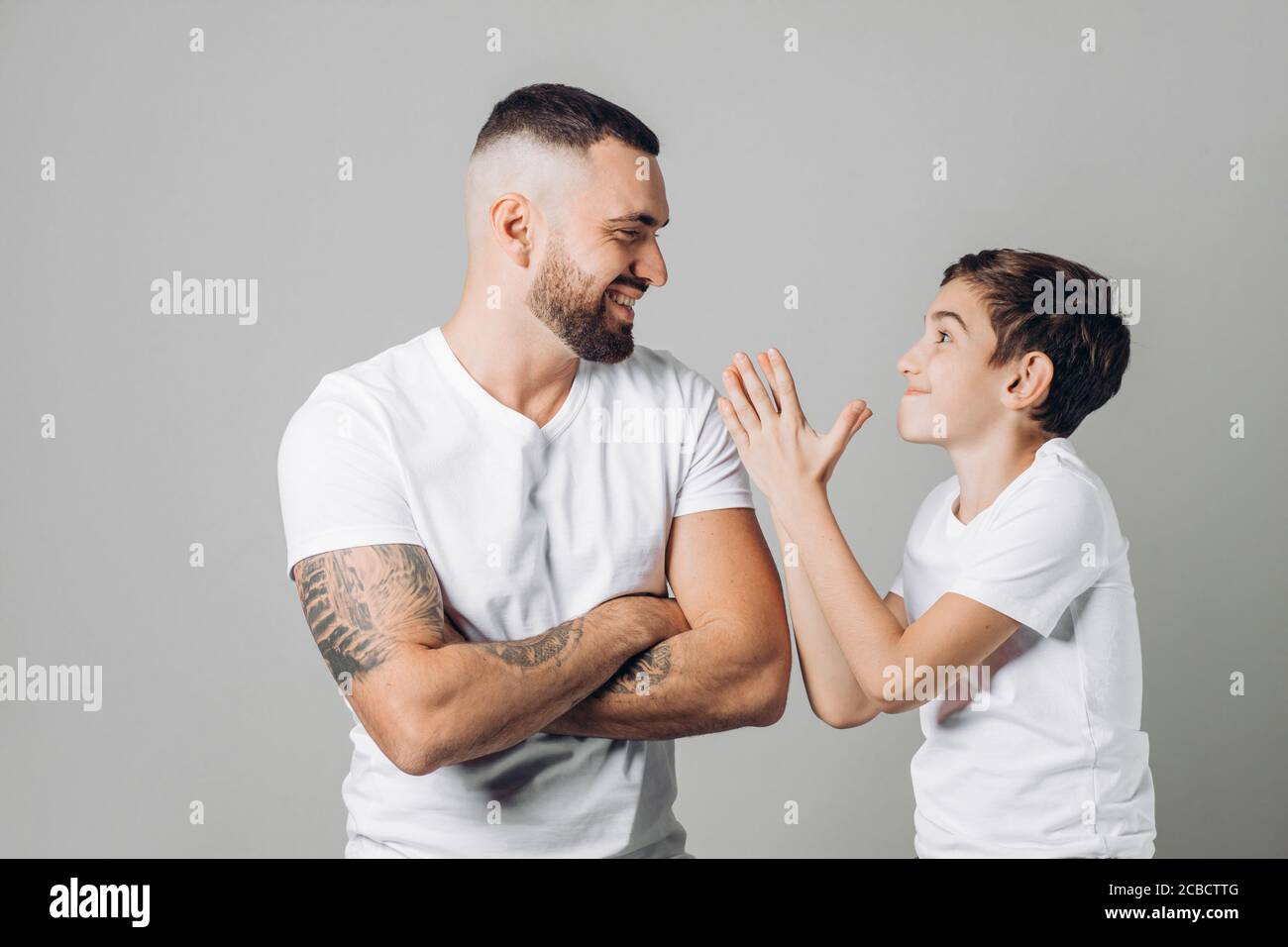 little boy with pleading or forgiveness gesture looking at his elder ...