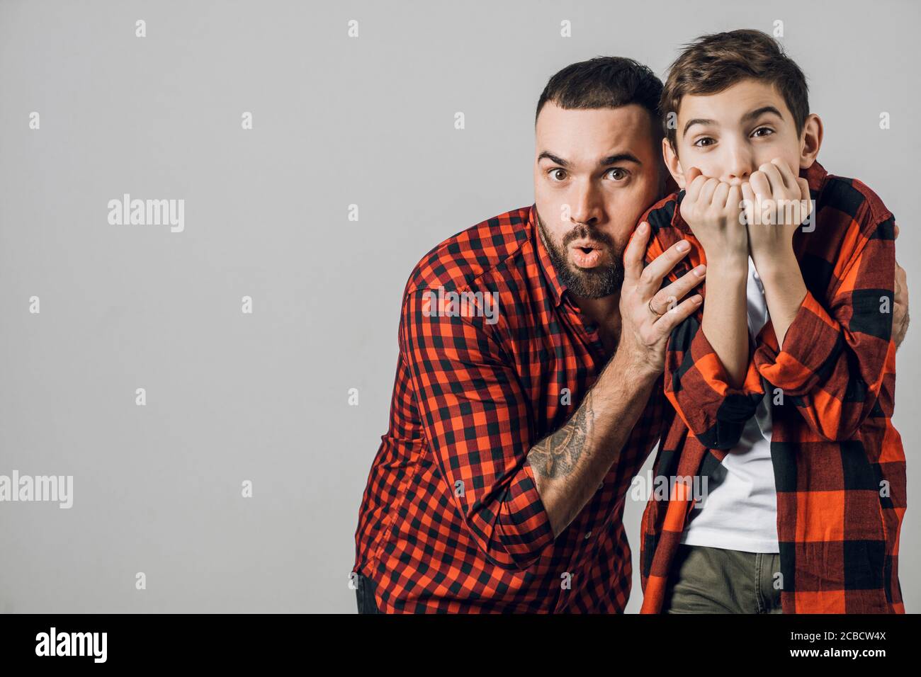 frightened man and his kid have scared expression. scared family ...