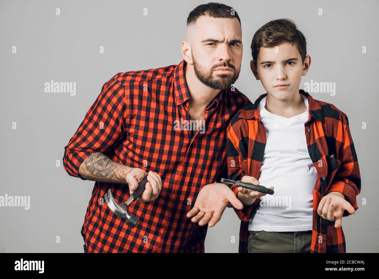 emotions. distrustful handsome bearded man and little boy looking at te ...