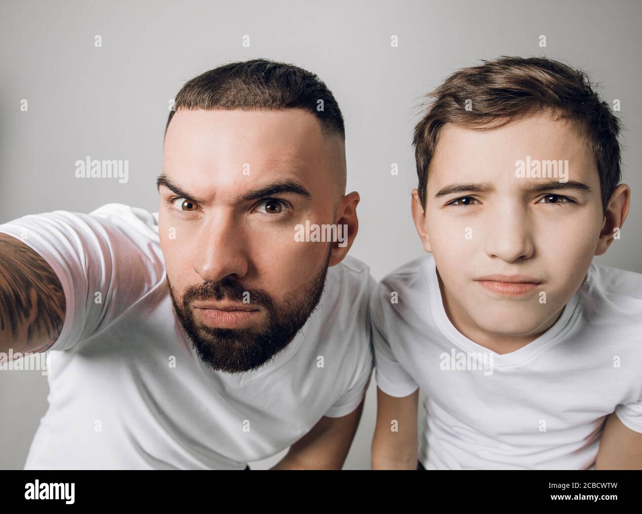 puzzled two brothers are taking photos. close up portrait. first selfie ...