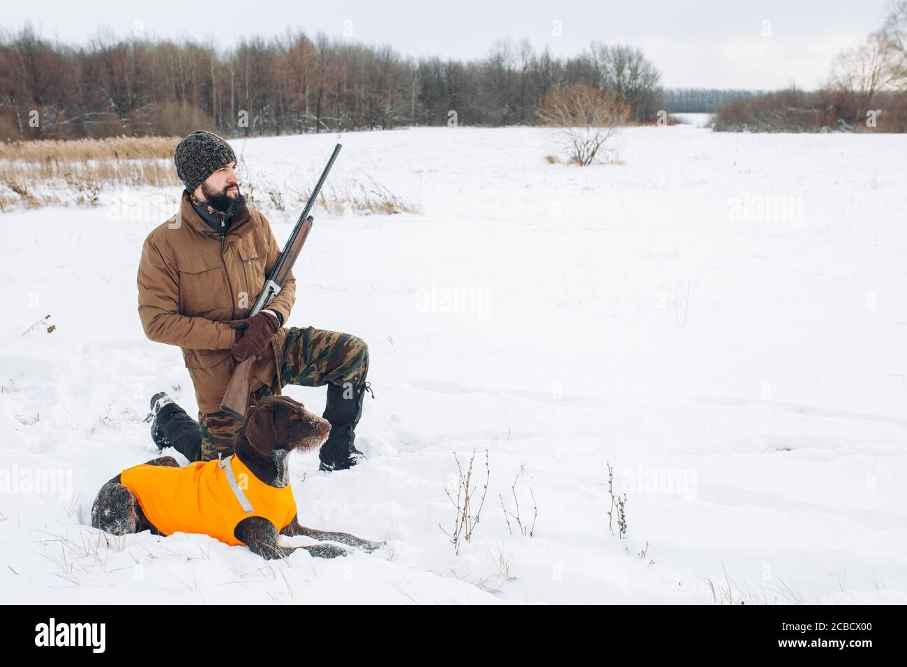 handsome hunter and his pet are waiting for a victim. side view full ...