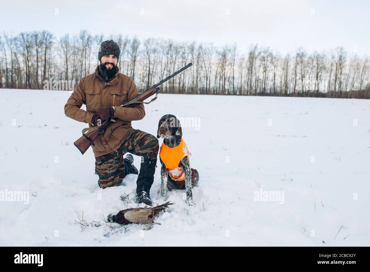 happy hunter with dog and their game. full length photo. good day for ...