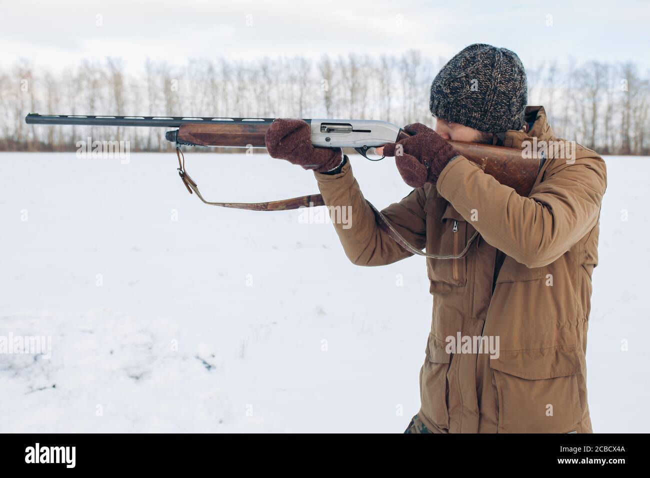 cruel hunter is pointing a gun to the aim. side view close up photo ...